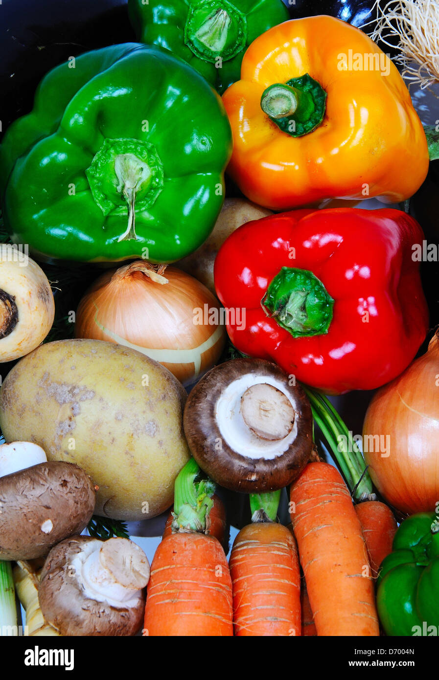 Selection of fresh vegetables including green, orange and red capsicum ...