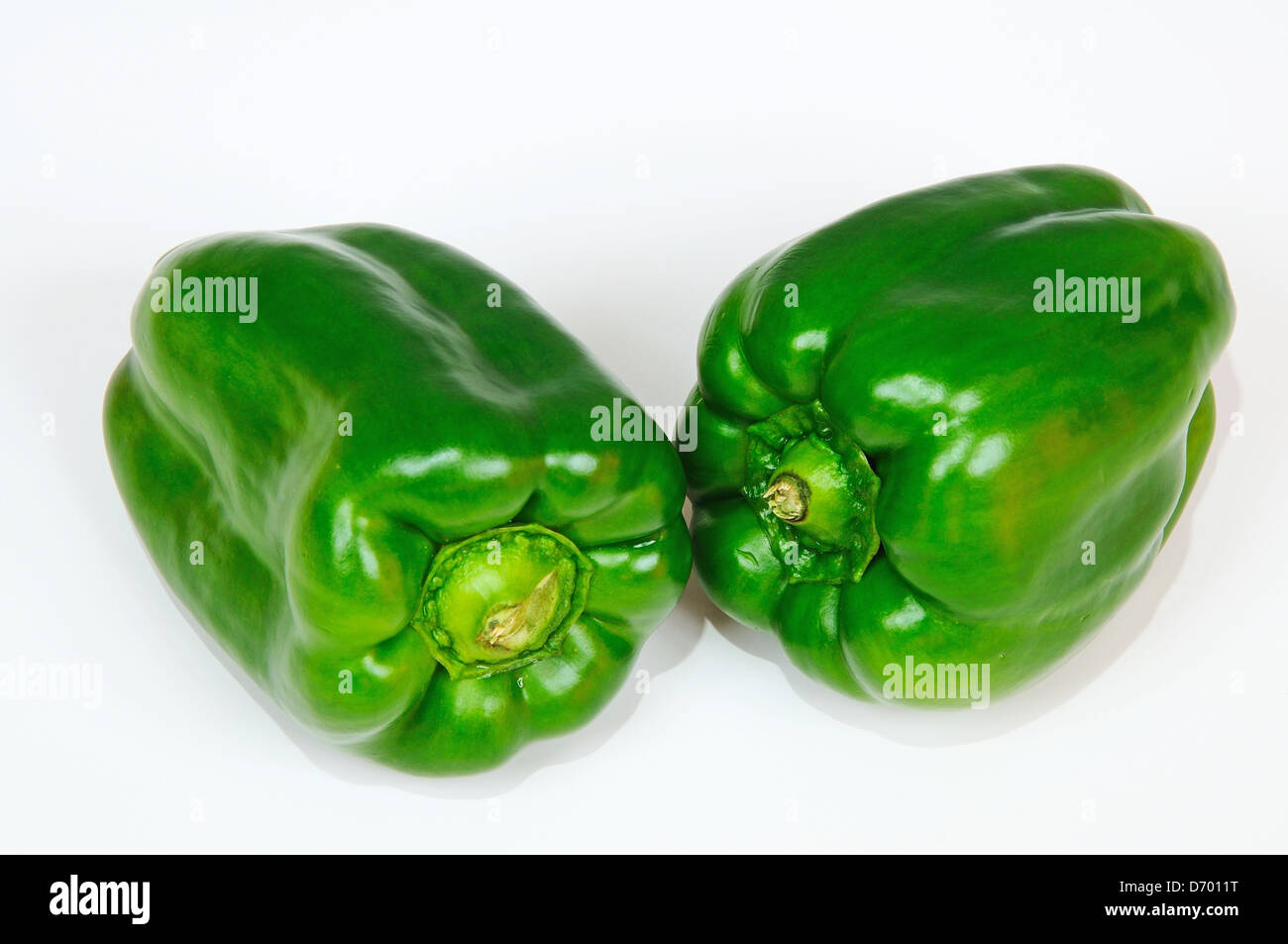 Two green capsicums against a white background Stock Photo - Alamy