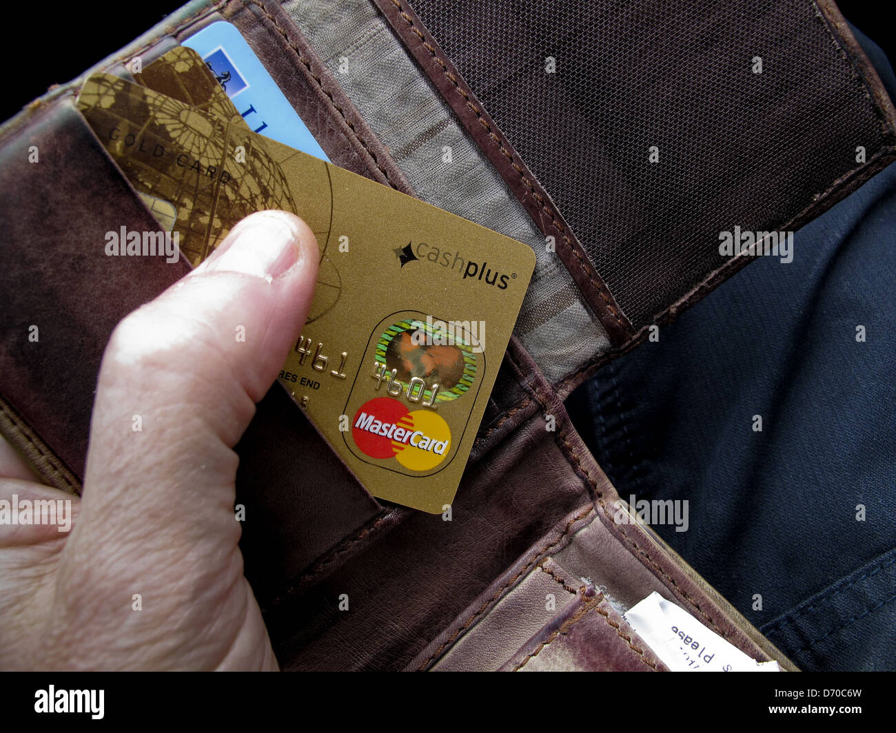 Man's hand holding gold credit card in leather wallet Stock Photo - Alamy