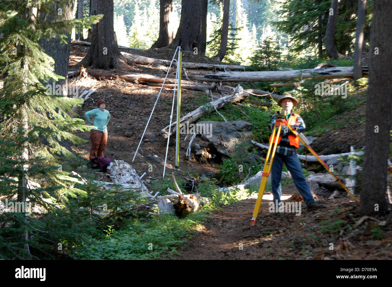 A USGS leveling crew conducts geological measurements in the woods near ...