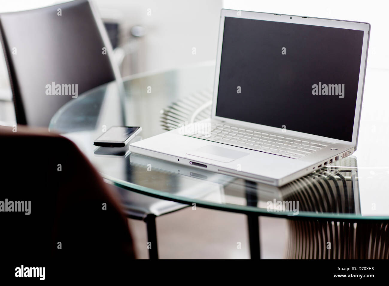 Computer and phone on dining room table Stock Photo - Alamy