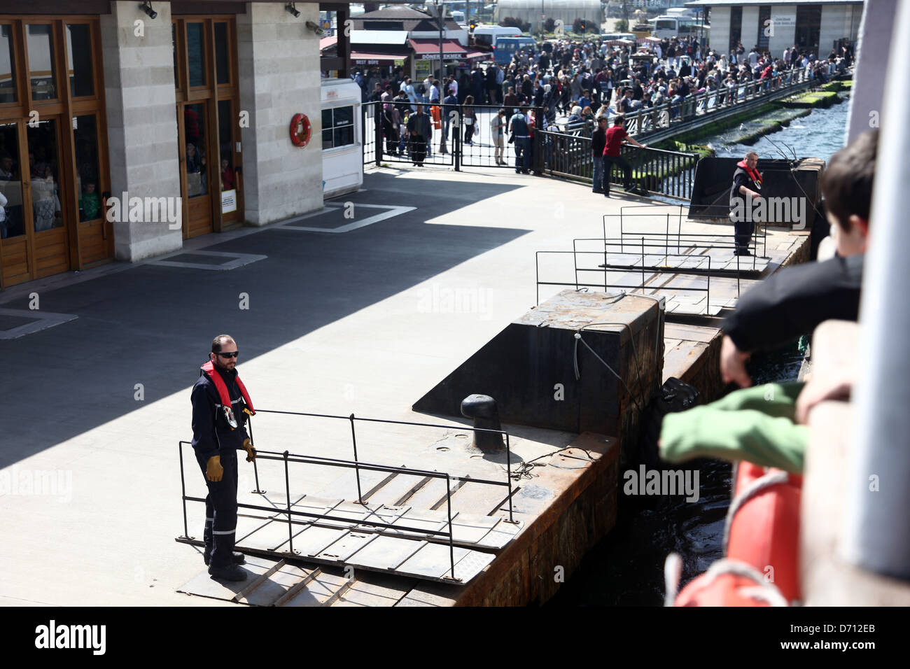 Ferry port worker waiting for the ferry to dock before moving the ramps ...