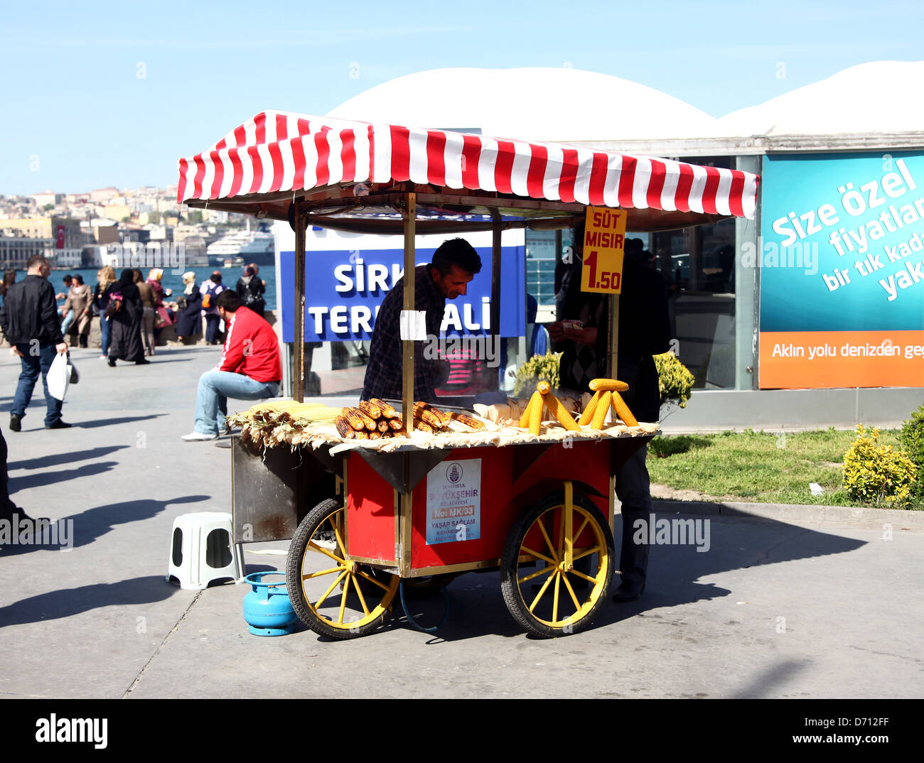 Street seller with a cart full of Sweet corn on the cob, cooked and ...