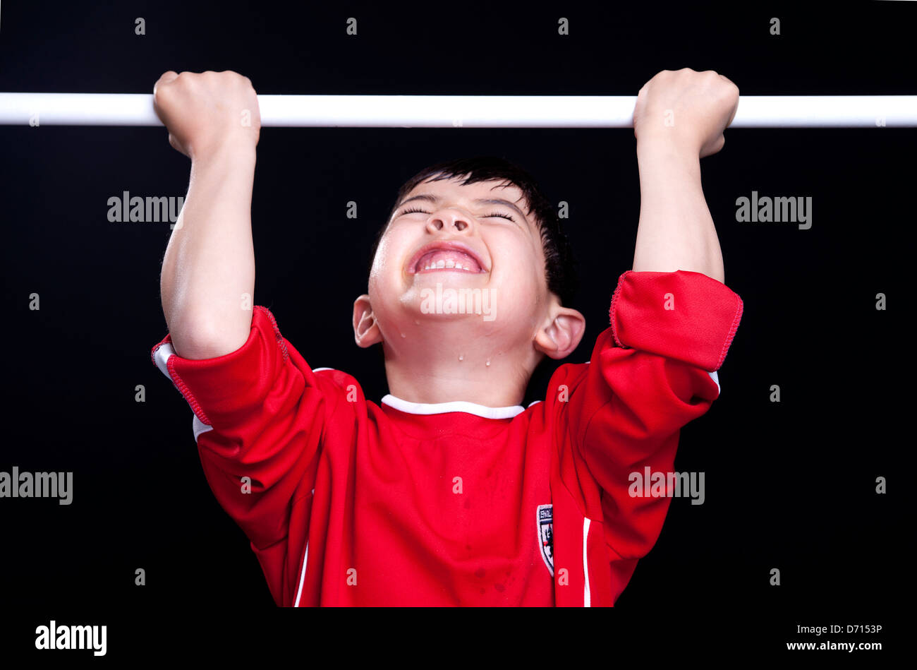 A young boy is determined to do a pull up Stock Photo - Alamy