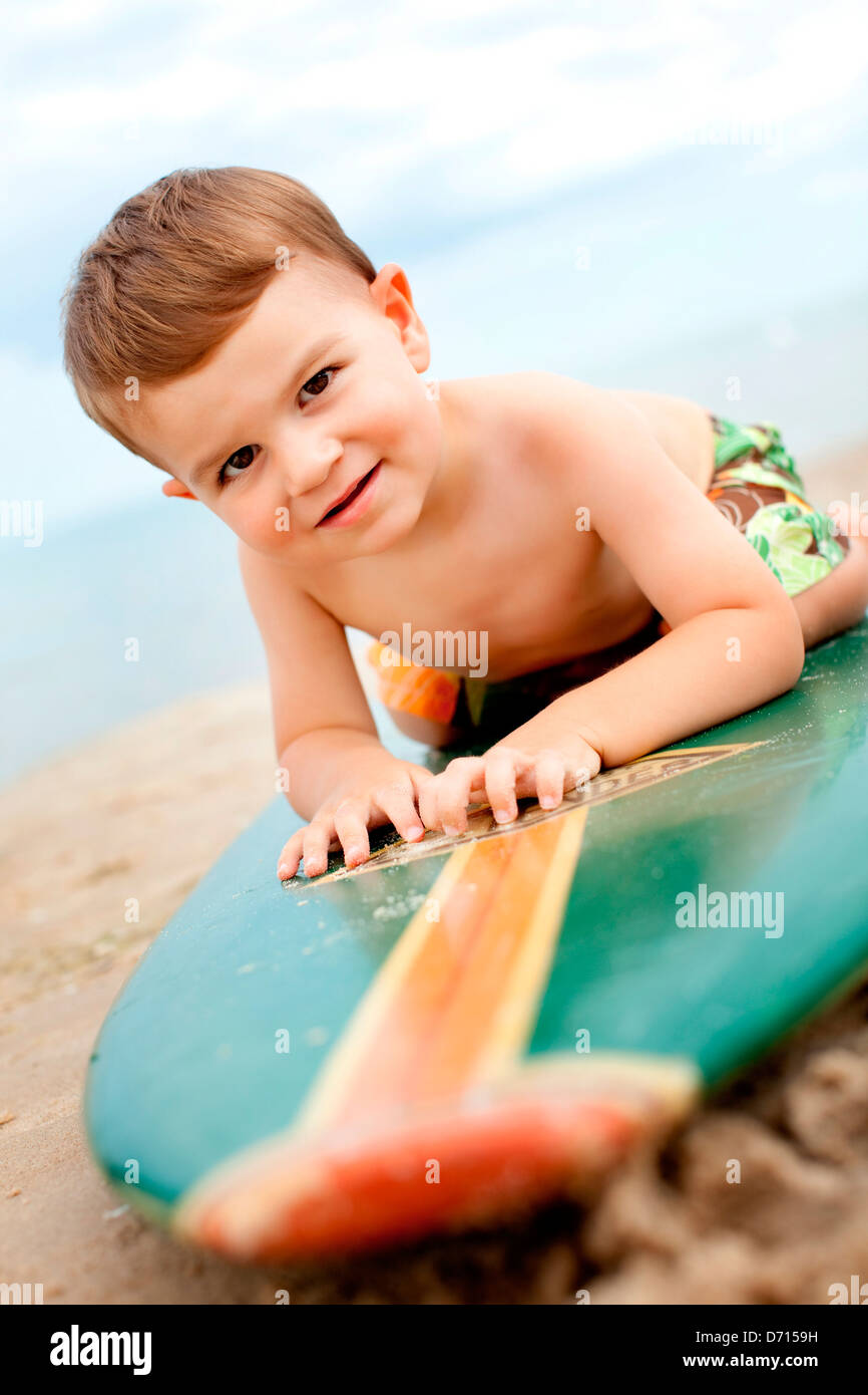 Boy lying on a surfboard on the beach, Glen Arbor, Leelanau County ...