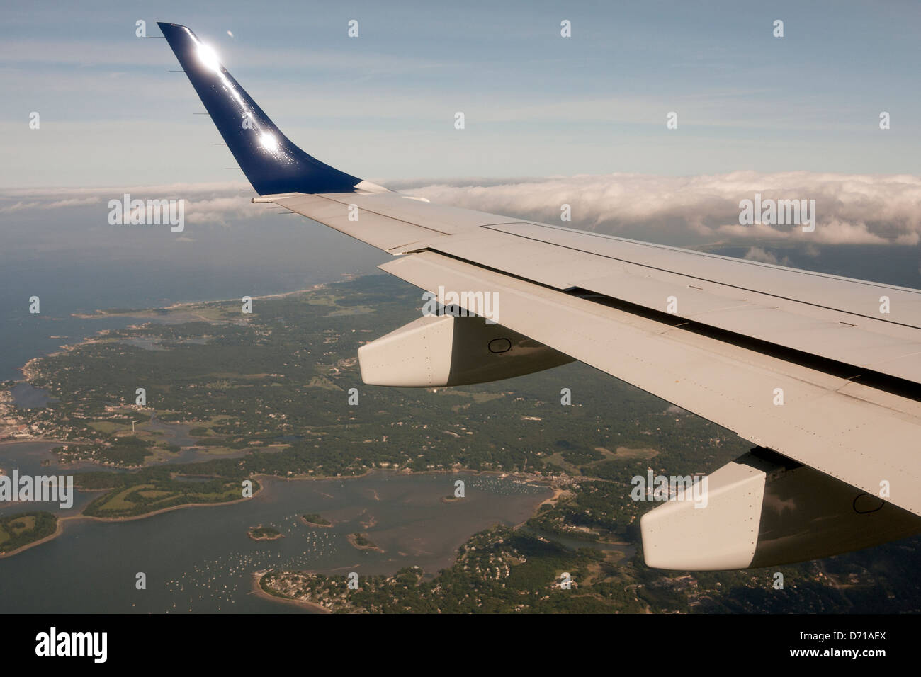 A plane flies over land and water as it makes its descent into Boston ...