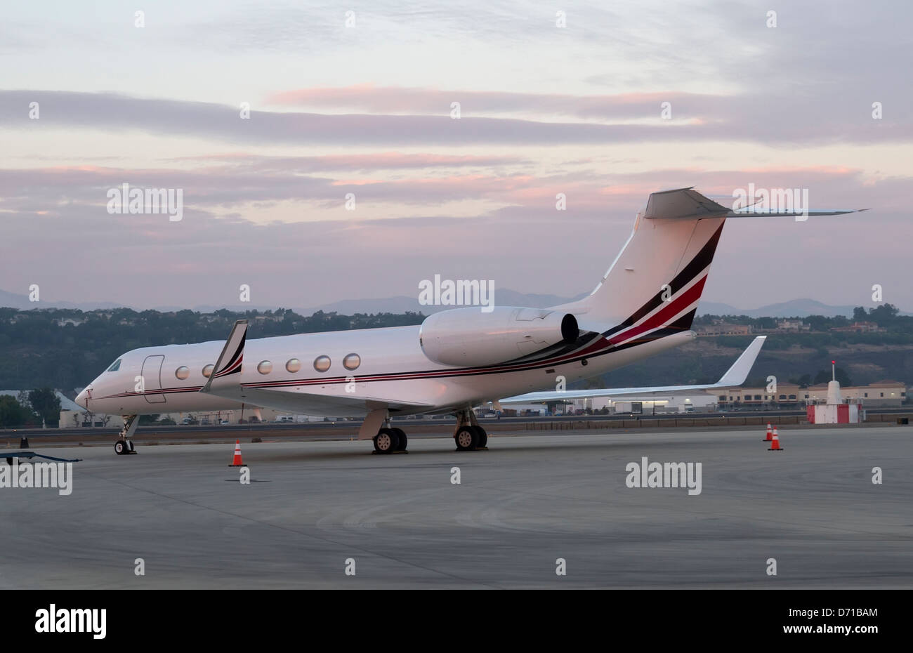 Private jet sitting on the runway at sunset Stock Photo - Alamy