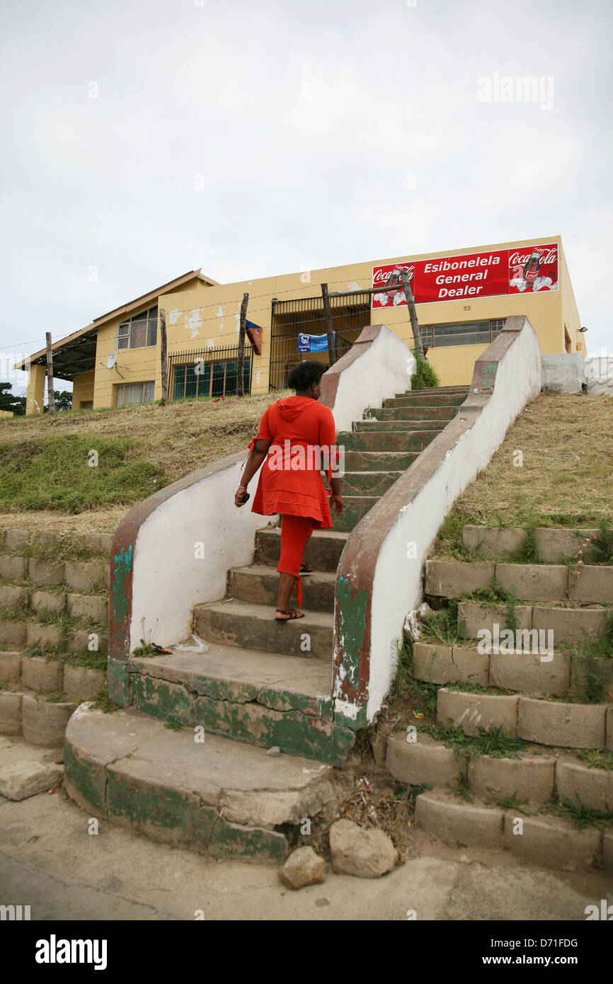 An African woman walks toward a small general dealer in Hamburg, South ...