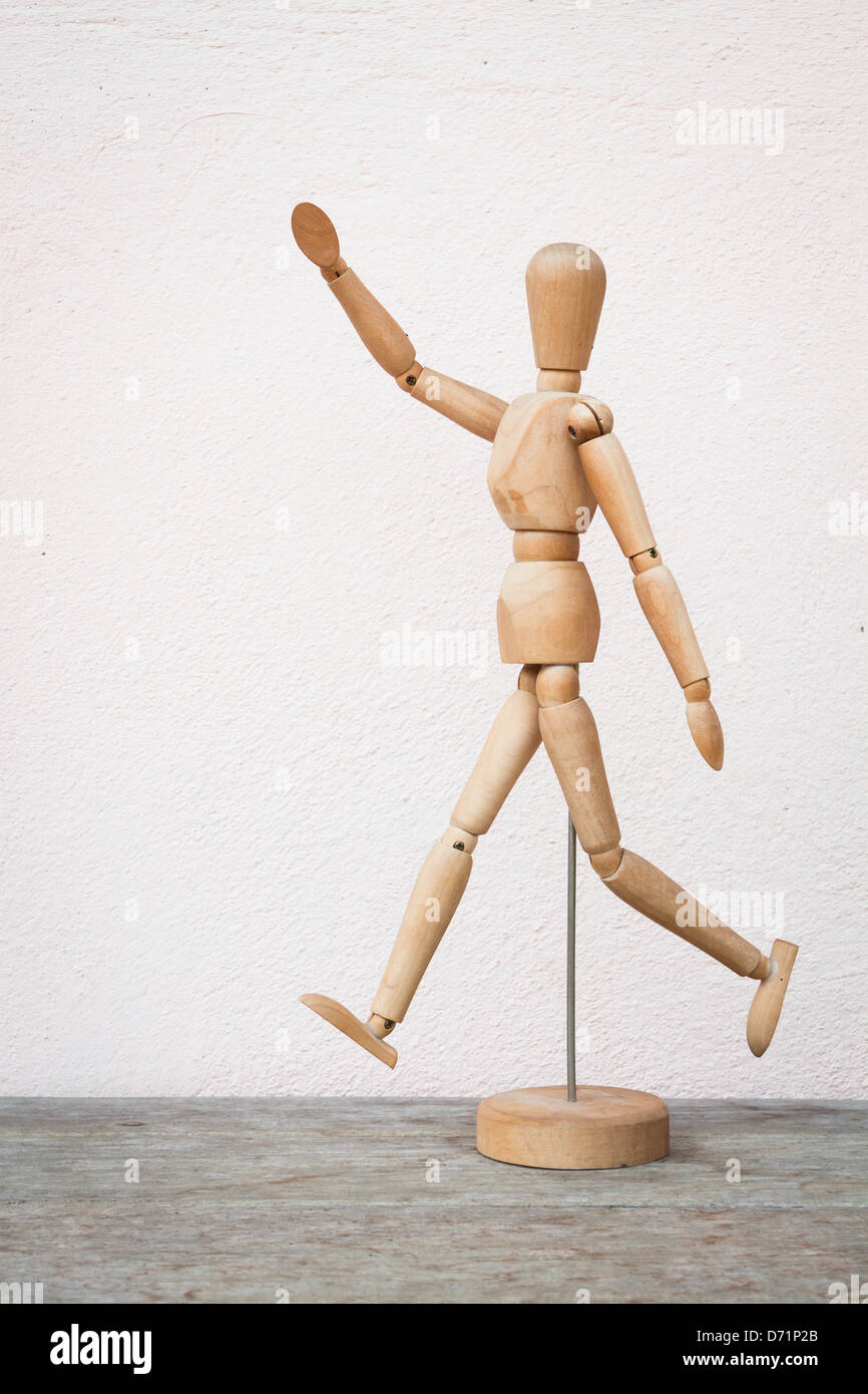 Wooden figure pose as happy jumping forward Stock Photo - Alamy