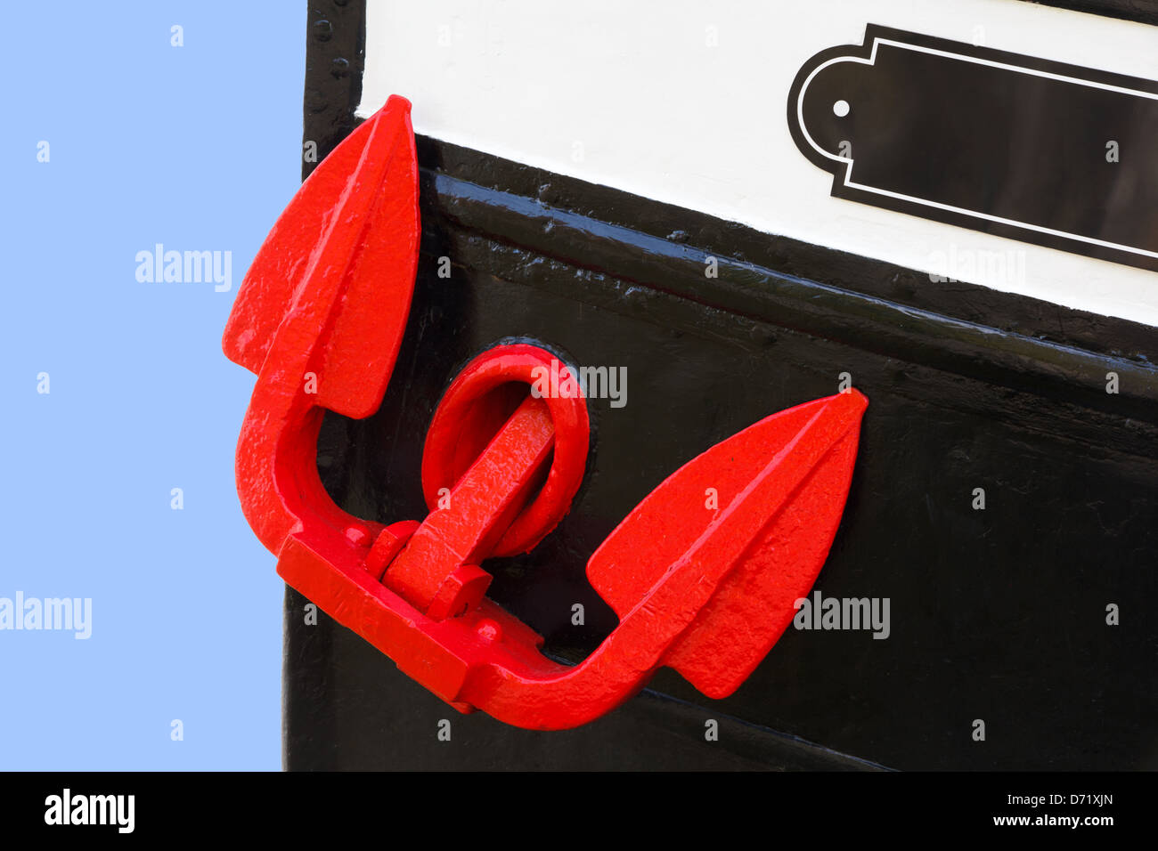 Red hoisted anchor on boat against blue background Stock Photo - Alamy