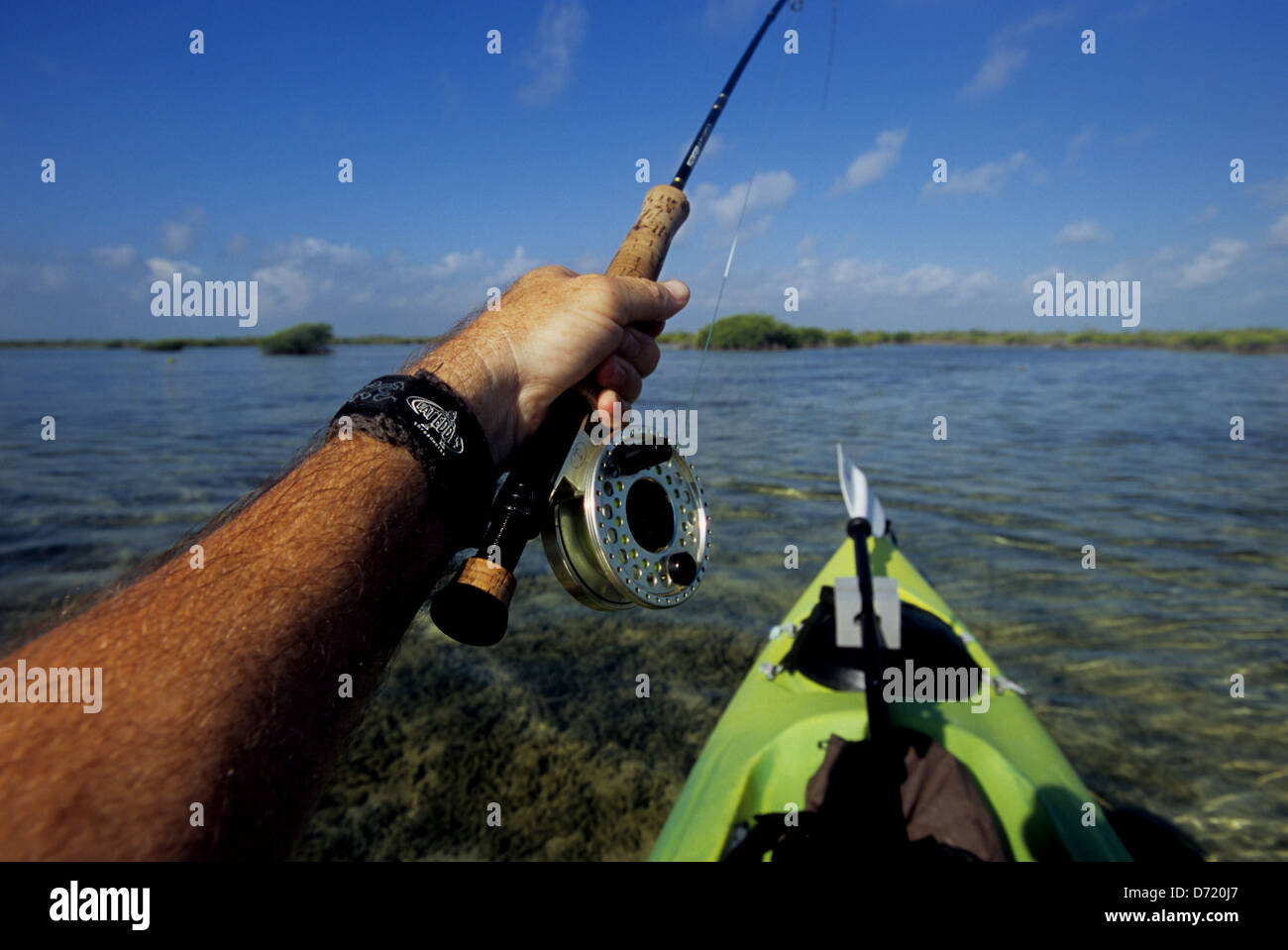 Angler fighting a bonefish from a kayak with a fly rod in Ascension Bay ...