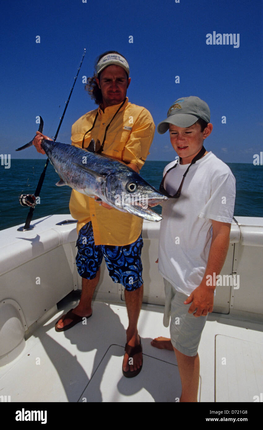 A fishing captain holds a King Mackerel (Scomberomorus cavalla) caught ...
