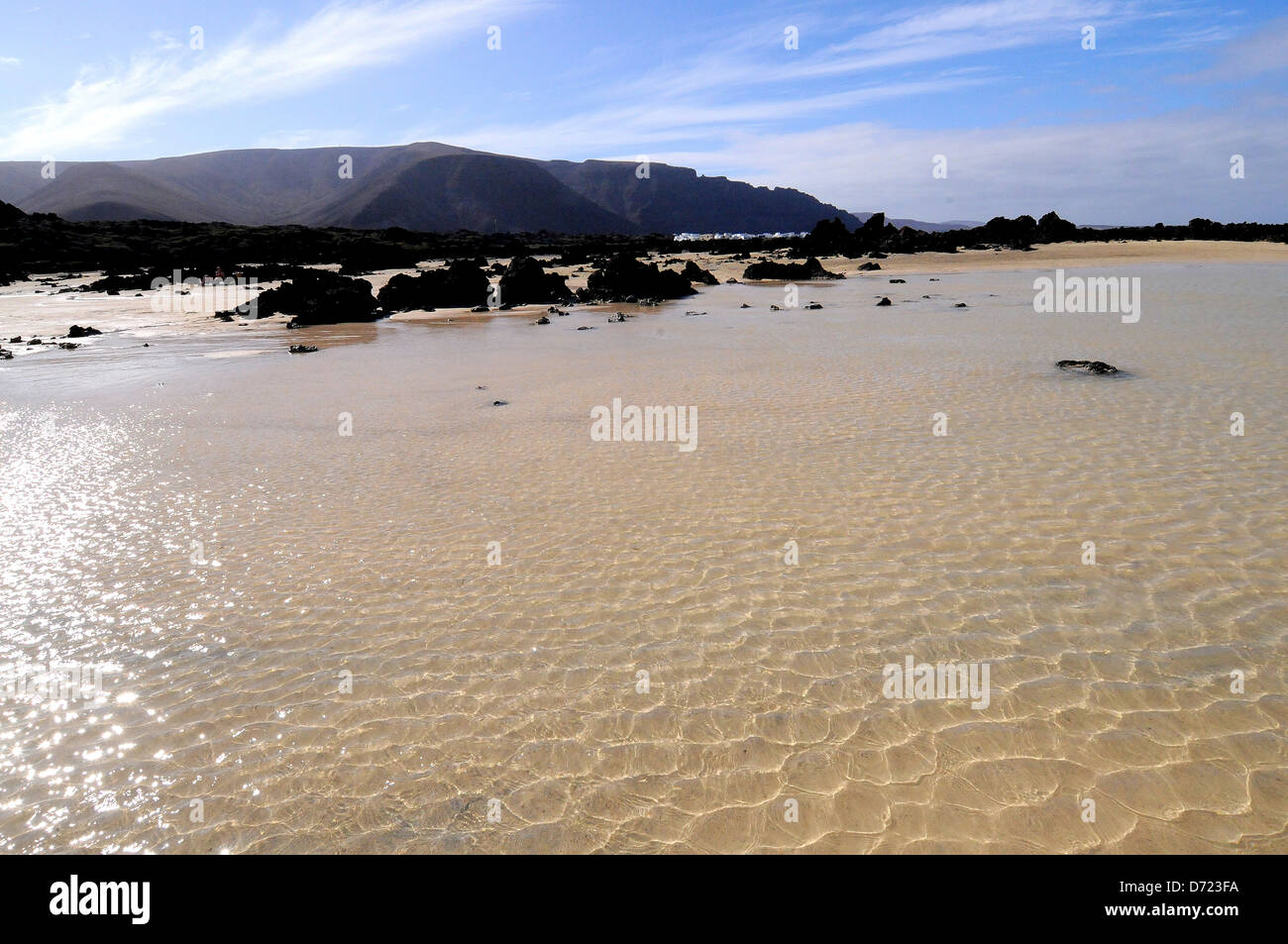 Shallow bay looking back across the water to mountains on the horizon ...
