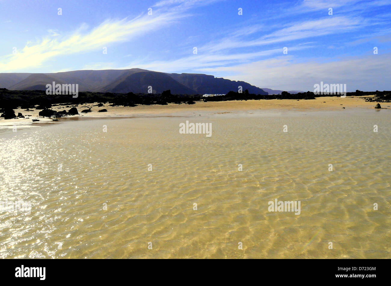Shallow bay looking back across the water to mountains on the horizon ...