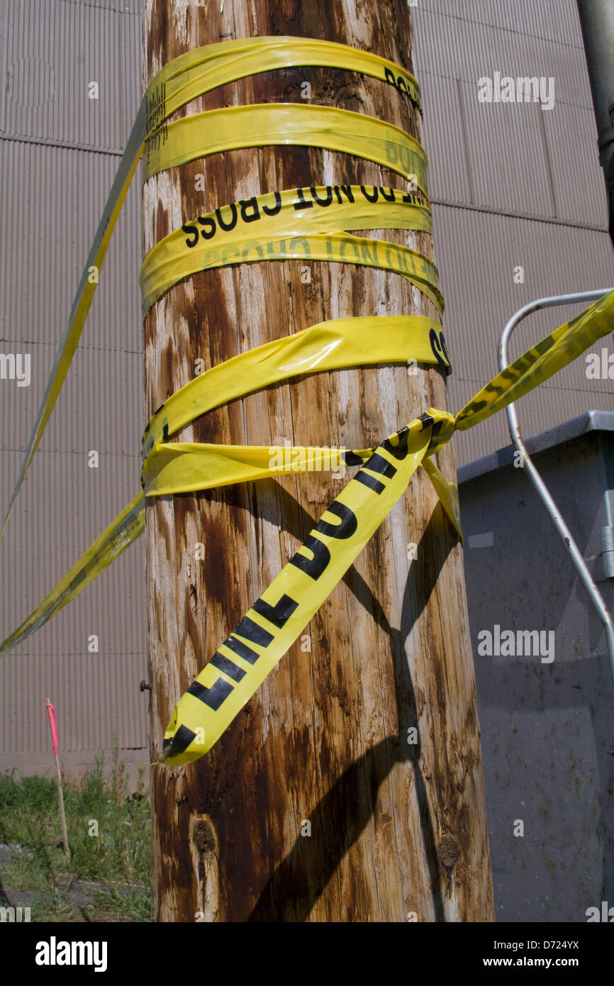 yellow police tape wrapped around and across objects. knotted and ...