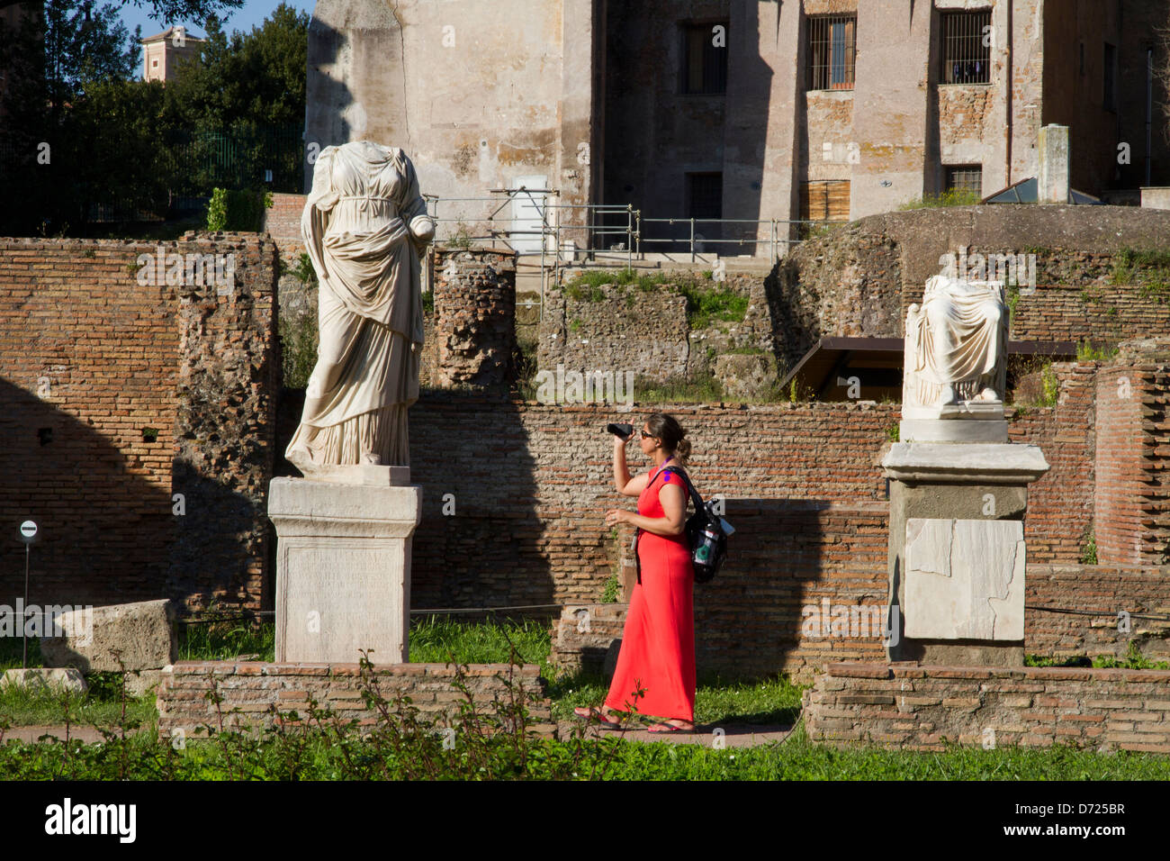 Tourist woman visiting and recording video at statues in Roman Forum ...