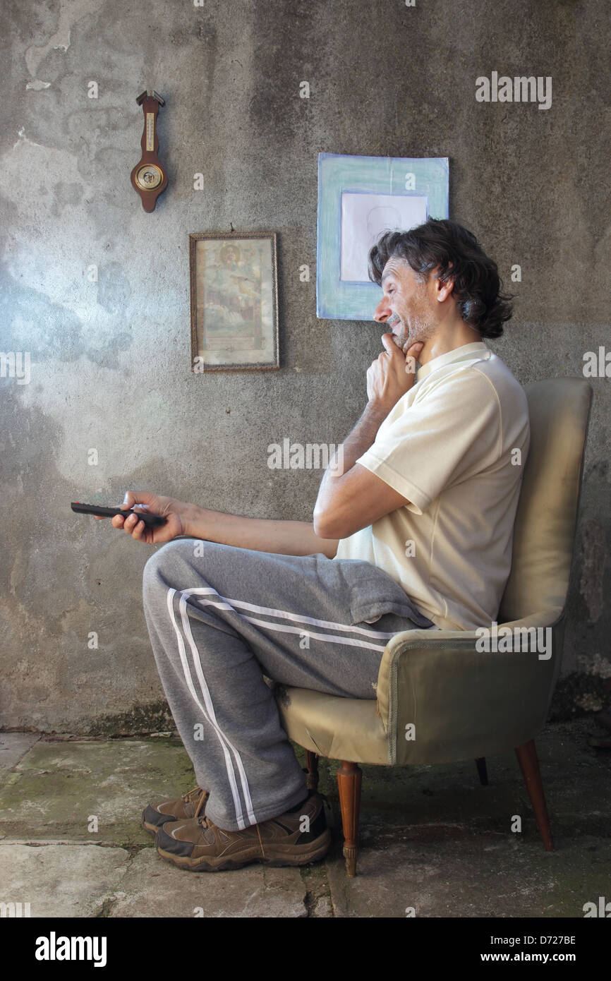 Man holding a remote control while watching TV Stock Photo - Alamy