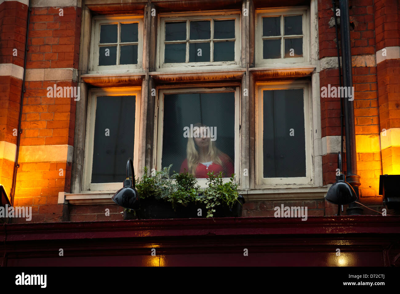 A woman looking out of the window Stock Photo - Alamy