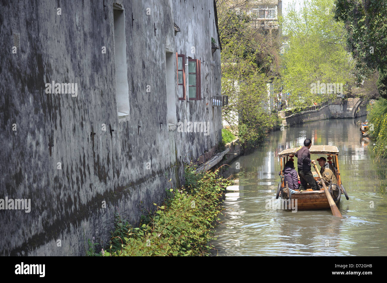 Traditional rowing boat taking tourists along the canal on Pingjianglu ...