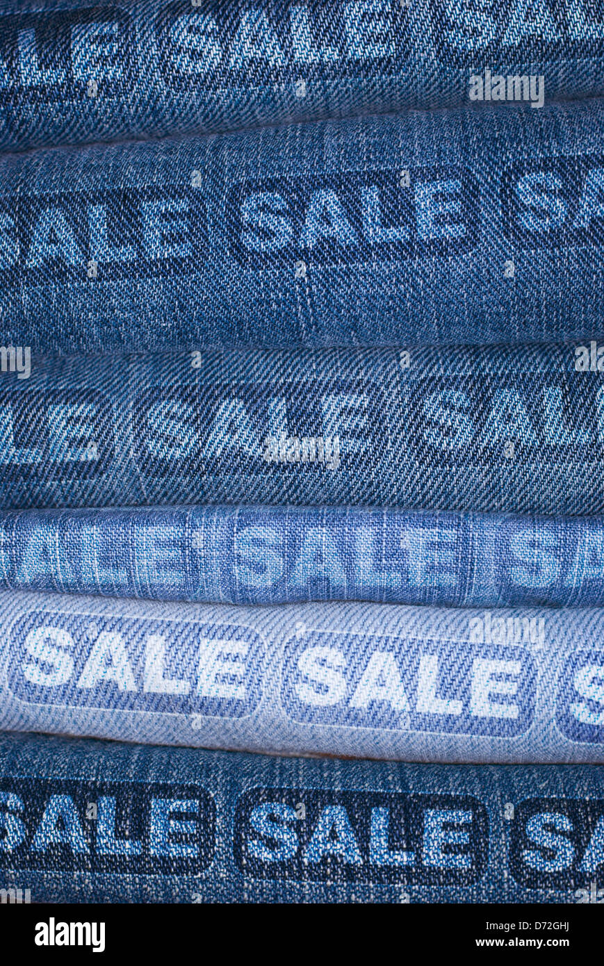 Sale Signs on Stack of Blue Jeans Stock Photo - Alamy