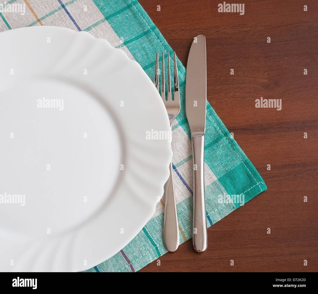 Dining time. Plate with silverware on table Stock Photo - Alamy