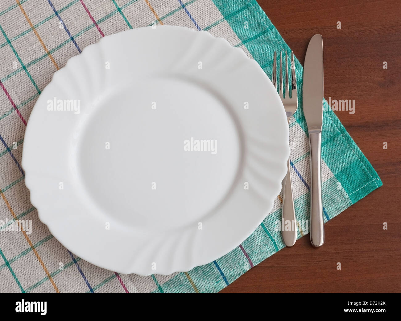 Dining time. Plate with silverware on table Stock Photo - Alamy
