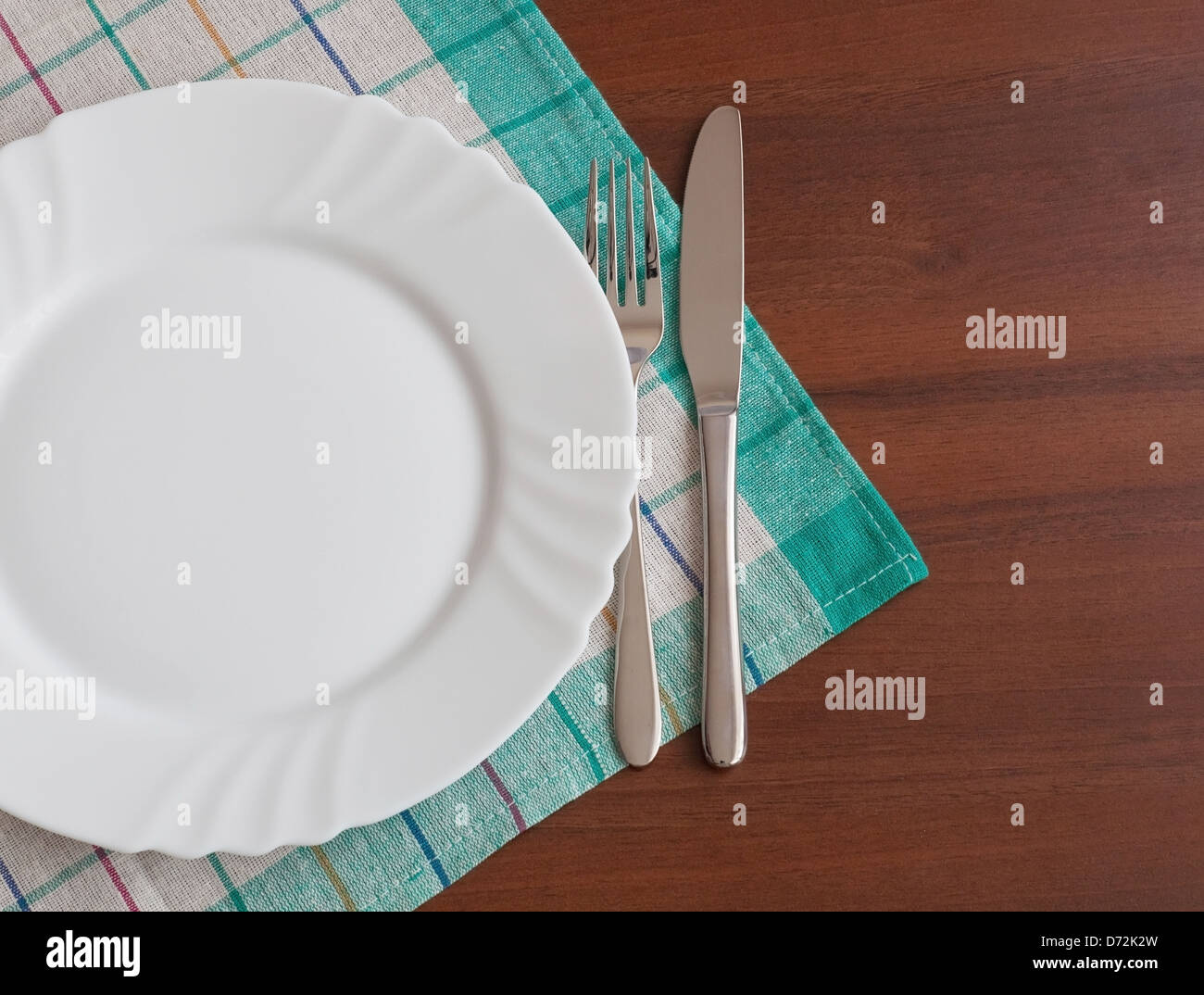 Dining time. Plate with silverware on table Stock Photo - Alamy