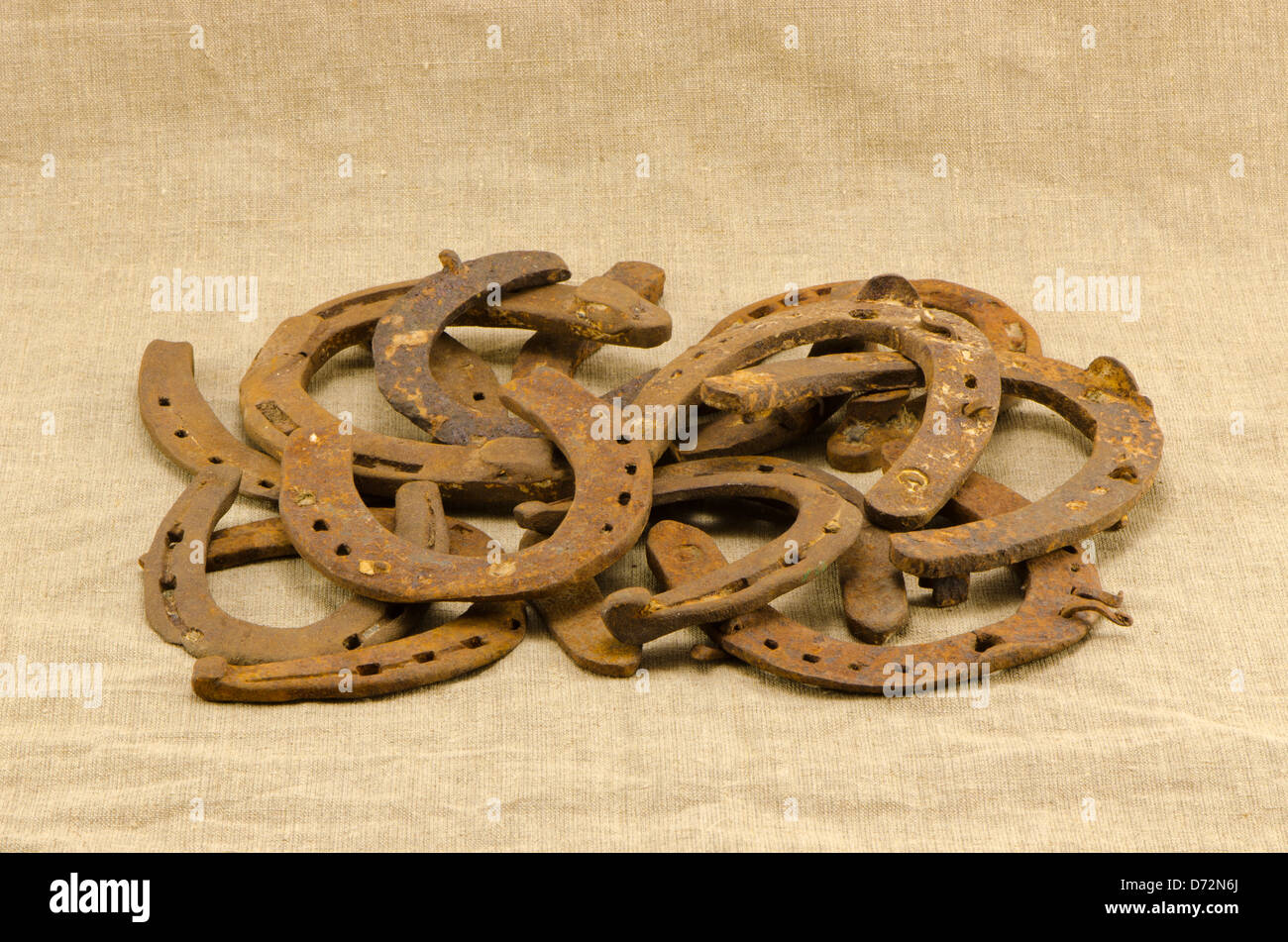 stack of old retro rusty horseshoes isolated on linen cloth cloth ...