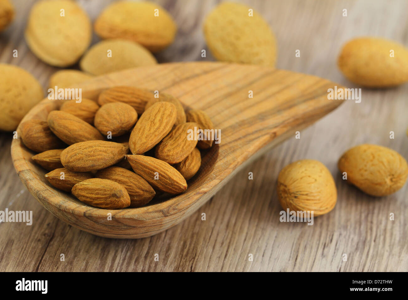 Almonds with and without shell on wooden background Stock Photo - Alamy