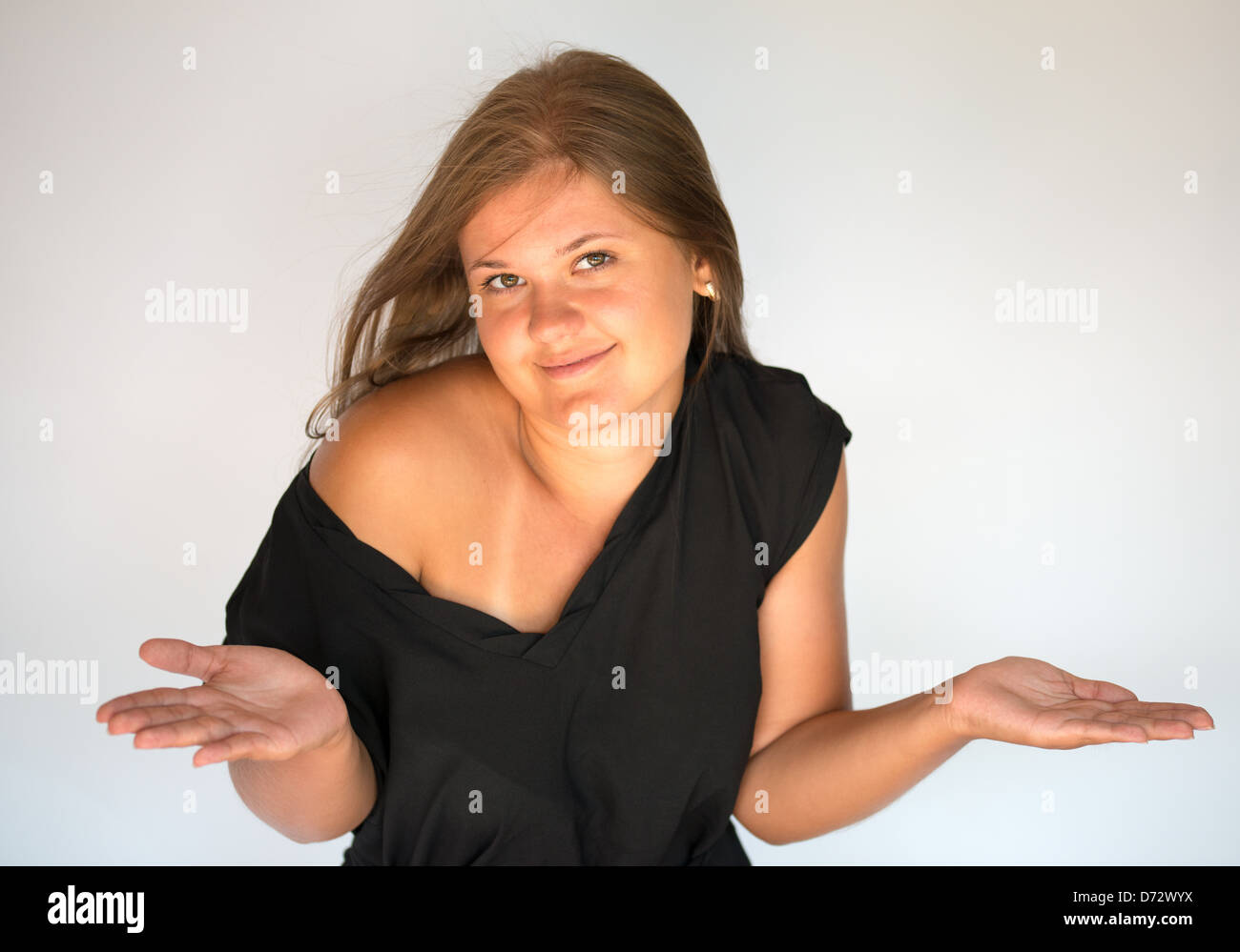 young blond woman shaking her shoulder with curious face expression ...