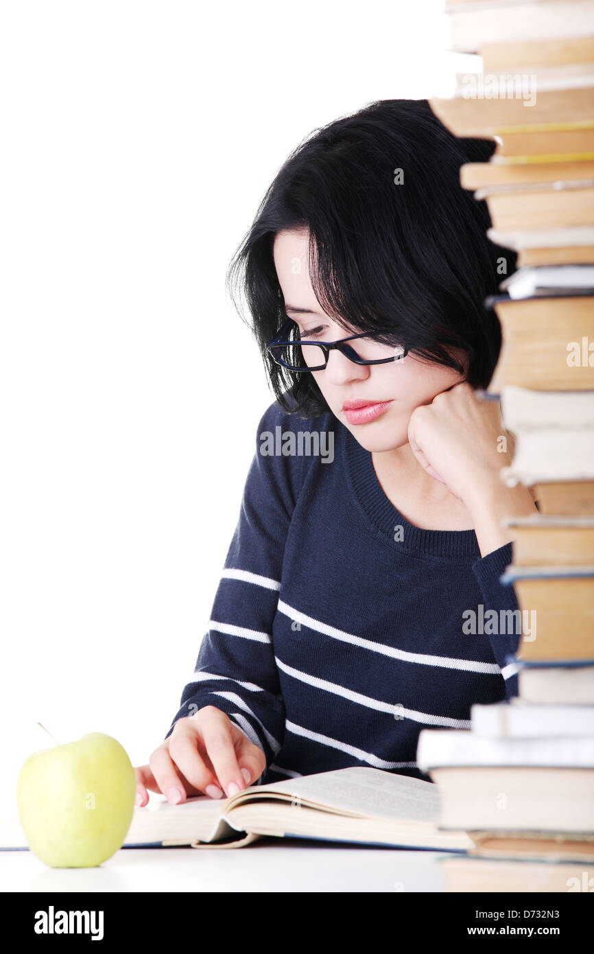 Young student woman with books studying at the desk, isolated on white ...