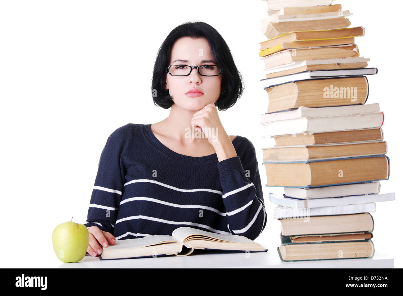 Young student woman with books studying at the desk, isolated on white ...