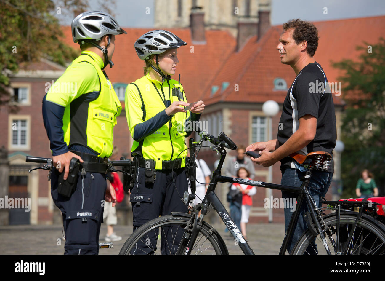 Muenster, Germany, police officers on bicycle patrol control a cyclist ...