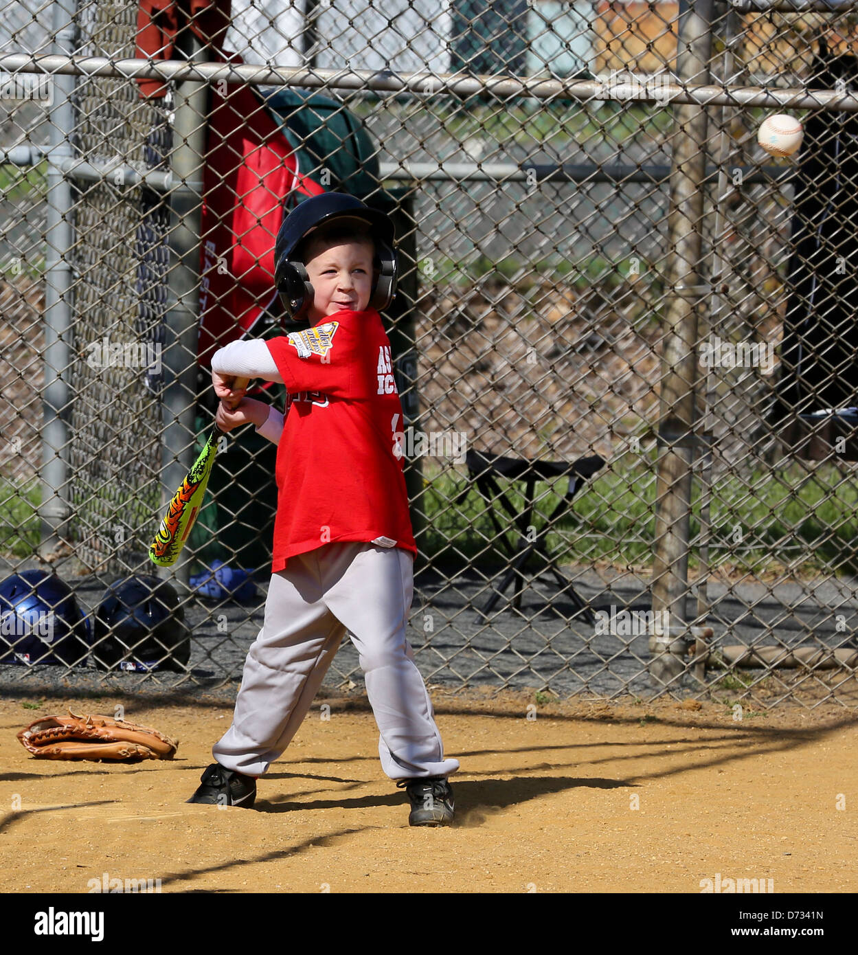 Funny face on a baseball players face as he swings the bat at the ball ...