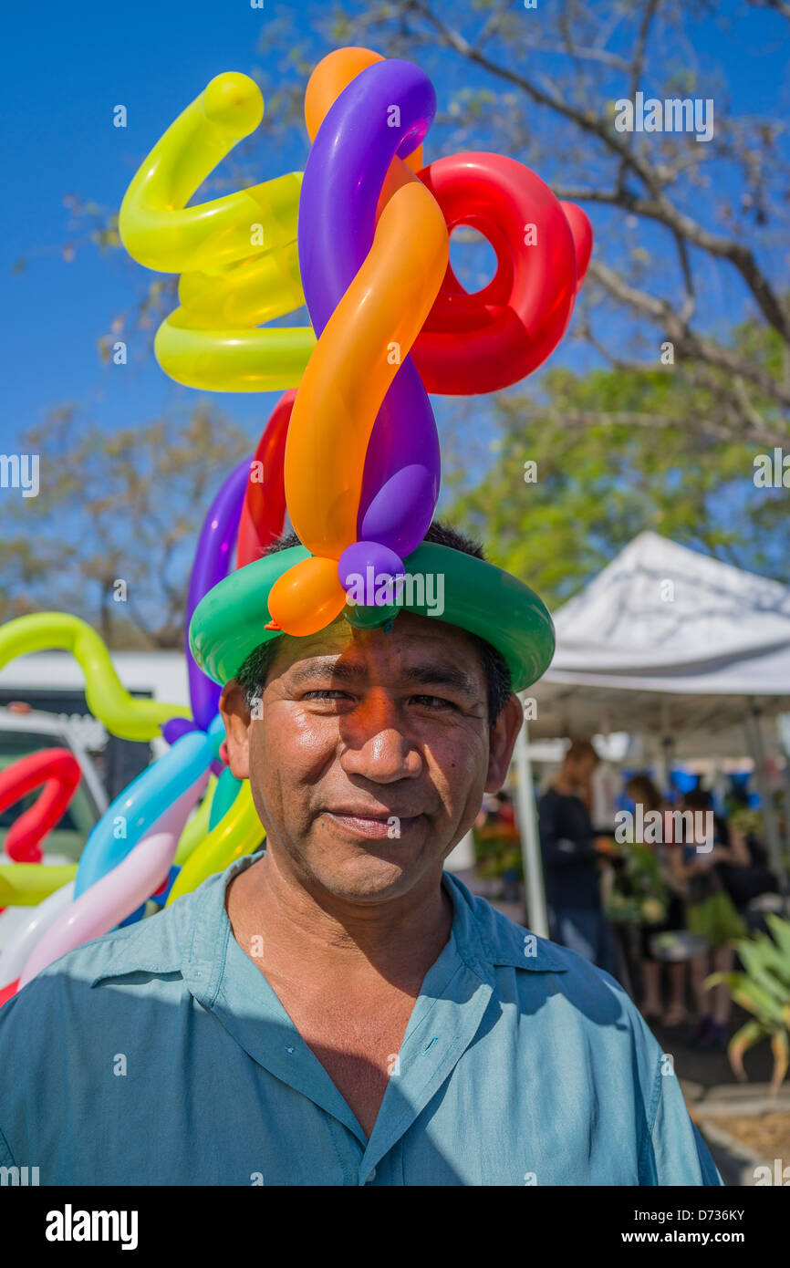 A balloon vendor who creates balloon art by tying them together wears ...