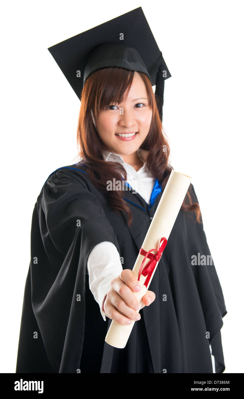 Portrait of smiling Asian female student in graduate gown showing ...