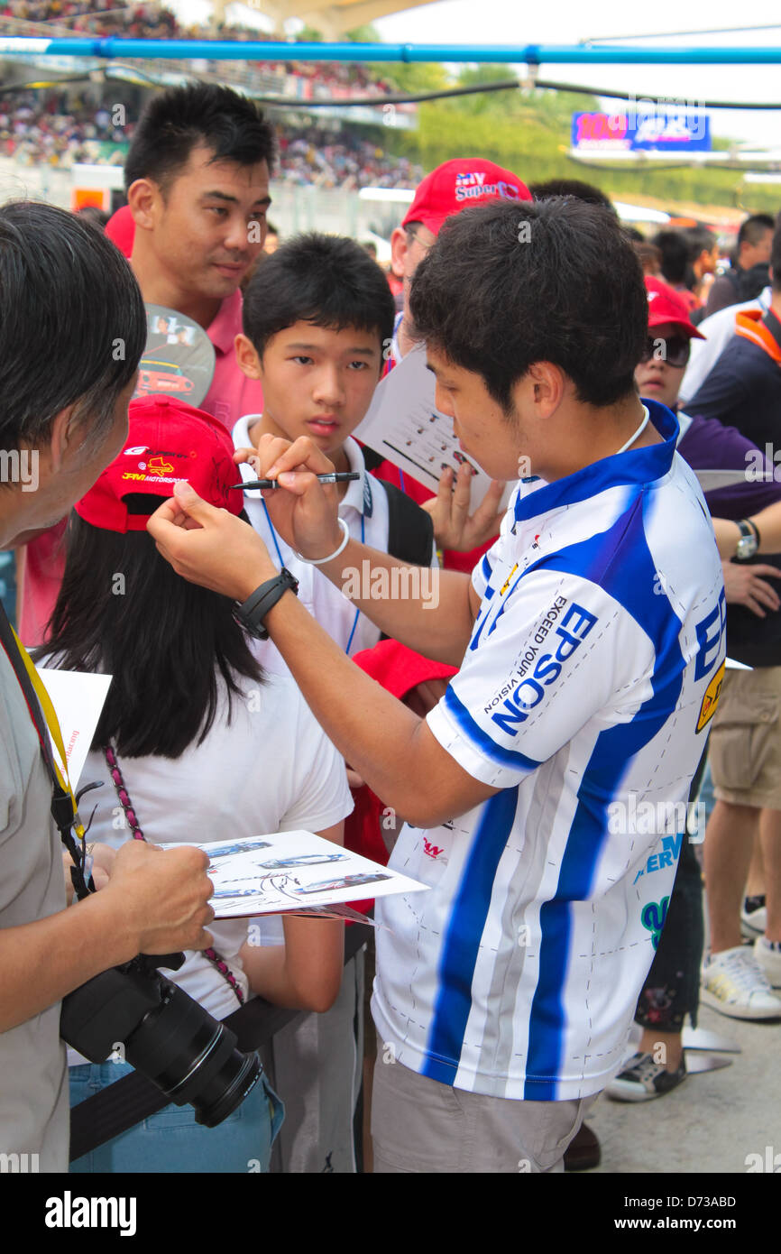 GT driver autographing on a spectator cap Stock Photo - Alamy