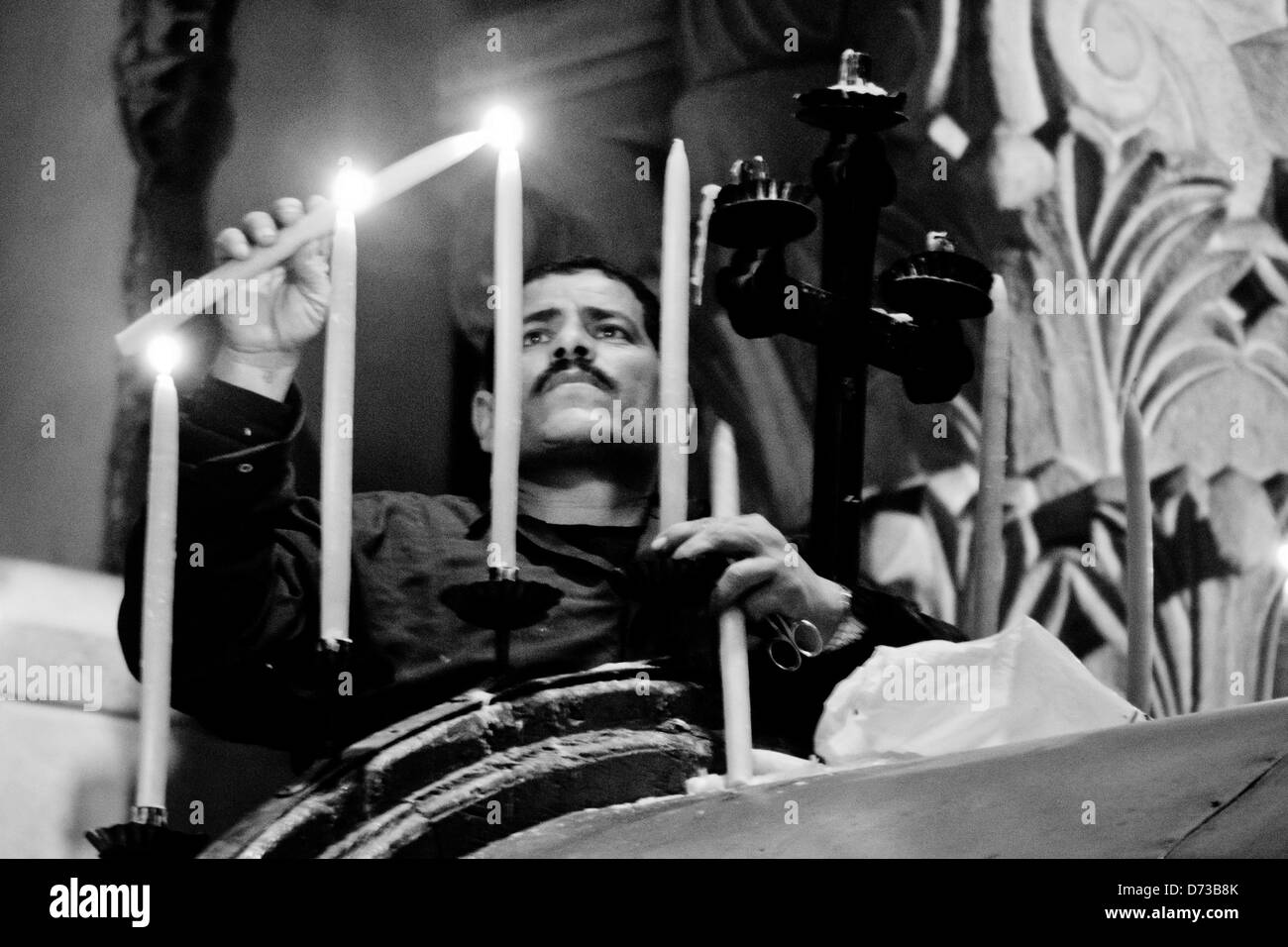 A man lights candles above the Coptic Chapel in the Church of The Holy ...