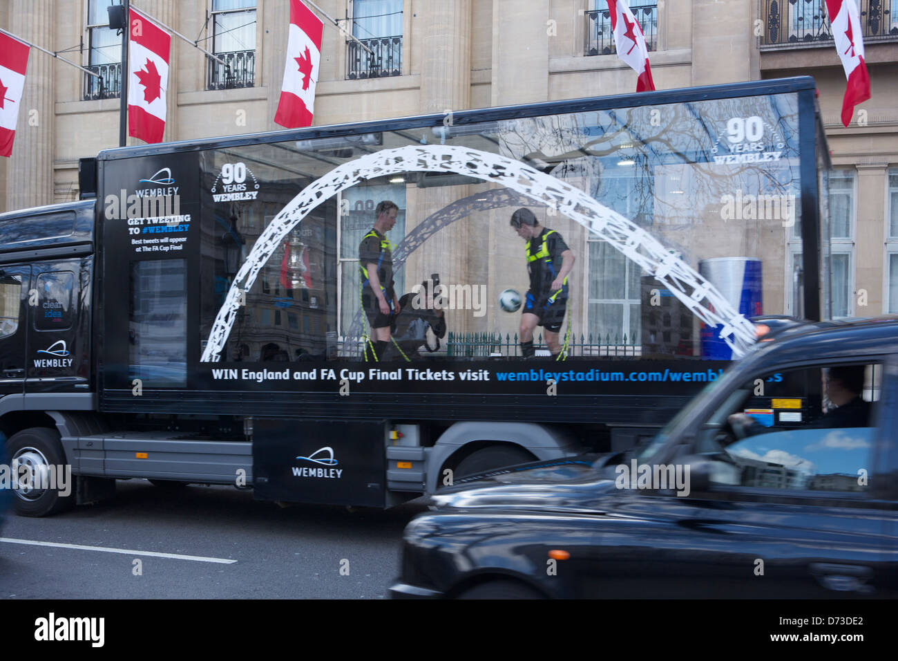 A truck carrying two men playing football to advertise Wembley stadium ...