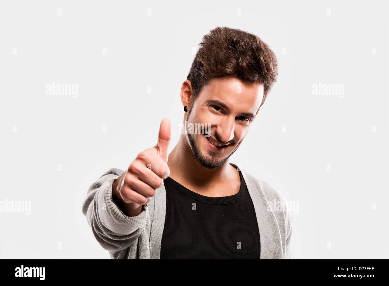 Handsome young man with thumbs up, over a gray background Stock Photo ...