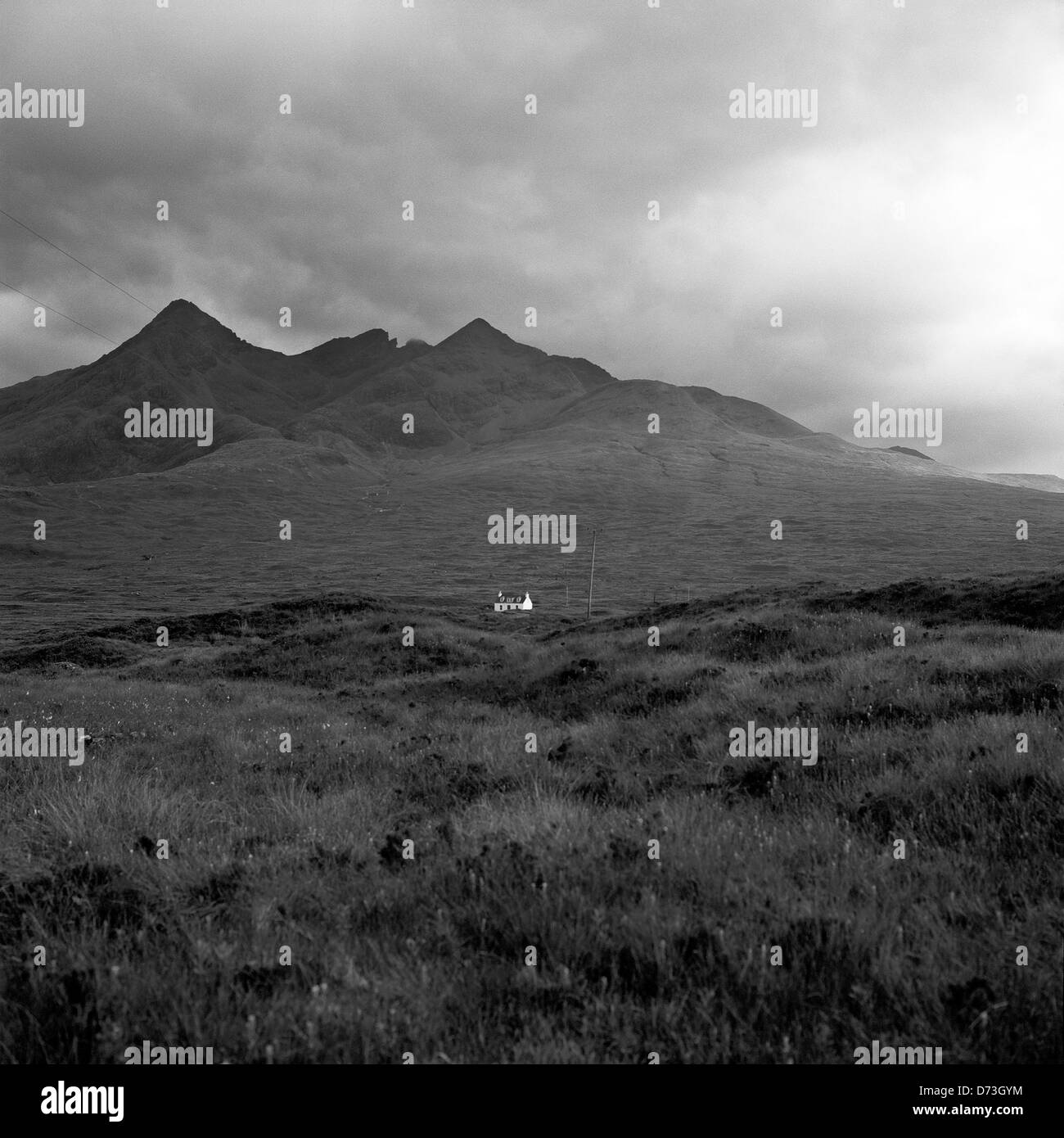 Drynoch, Scotland, look at a single home in front of the mountain range ...