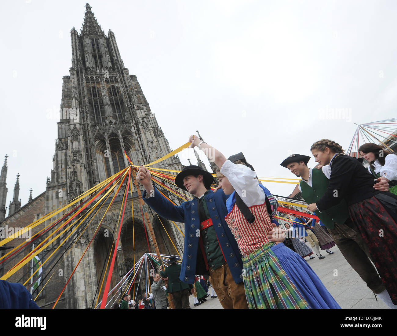 People in traditional costumes perform a maypole dance in Ulm, Germany ...