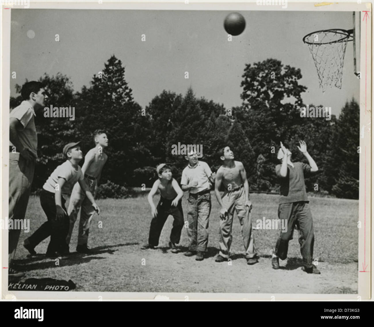 This image shows a group of boys playing basketball outside, possibly at a Jewish community ...
