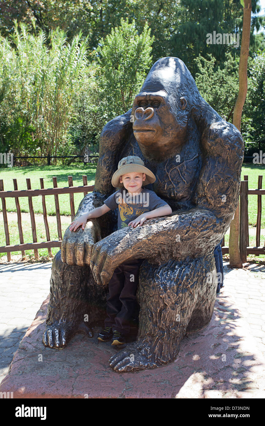 A young boy in a hat posing by a statue of Max the Gorilla at the ...