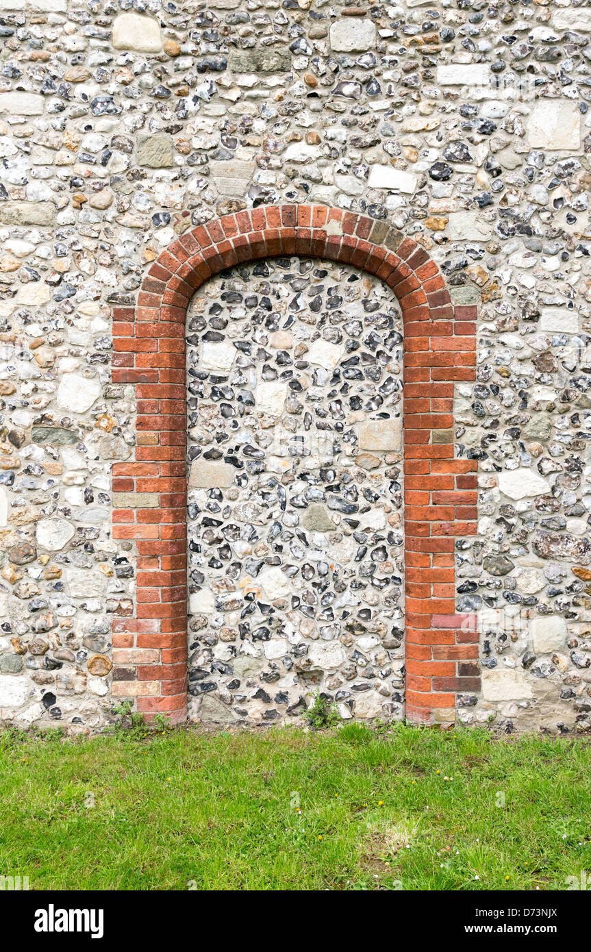 Blocked up doorway. Brick pillars and arch with flint and stone infill ...