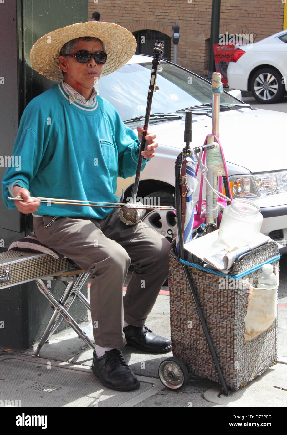An old chinese man playing an unusual musical instrument on the streets ...