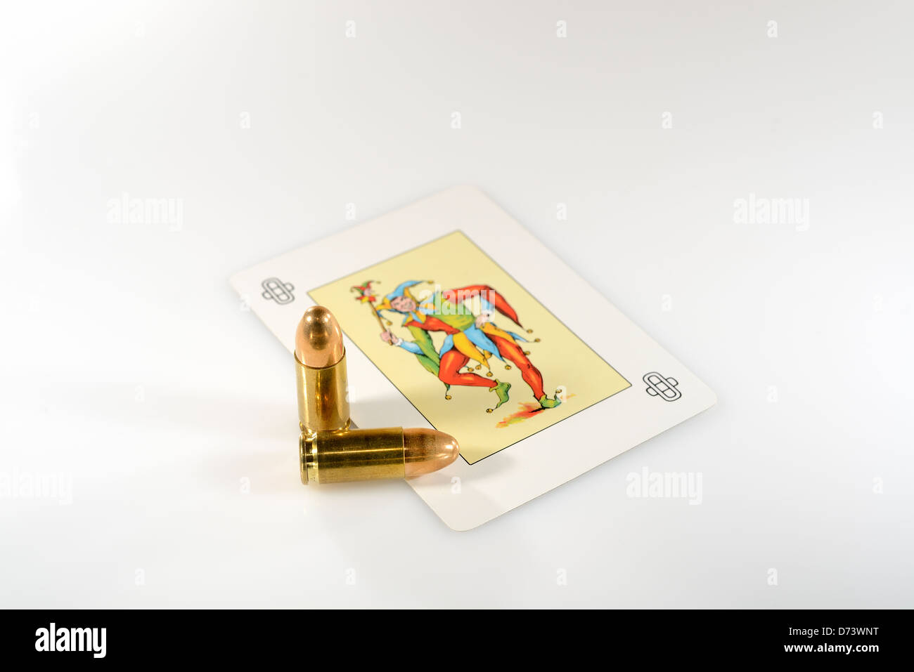 Joker card and two bullets on white background Stock Photo - Alamy
