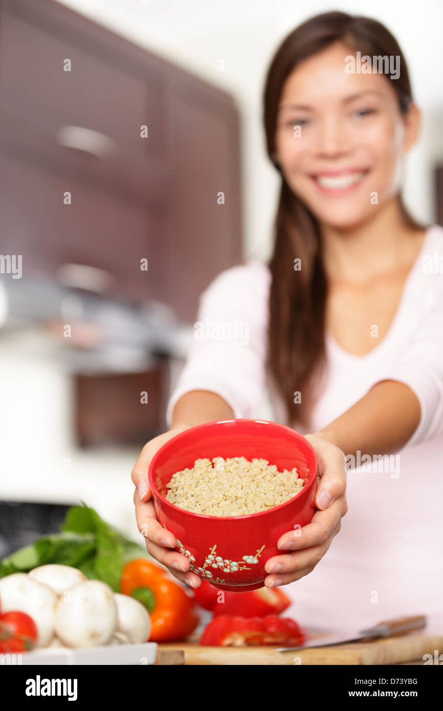 quinoa. Woman showing bowl of cooking quinoa to use for healthy salad ...