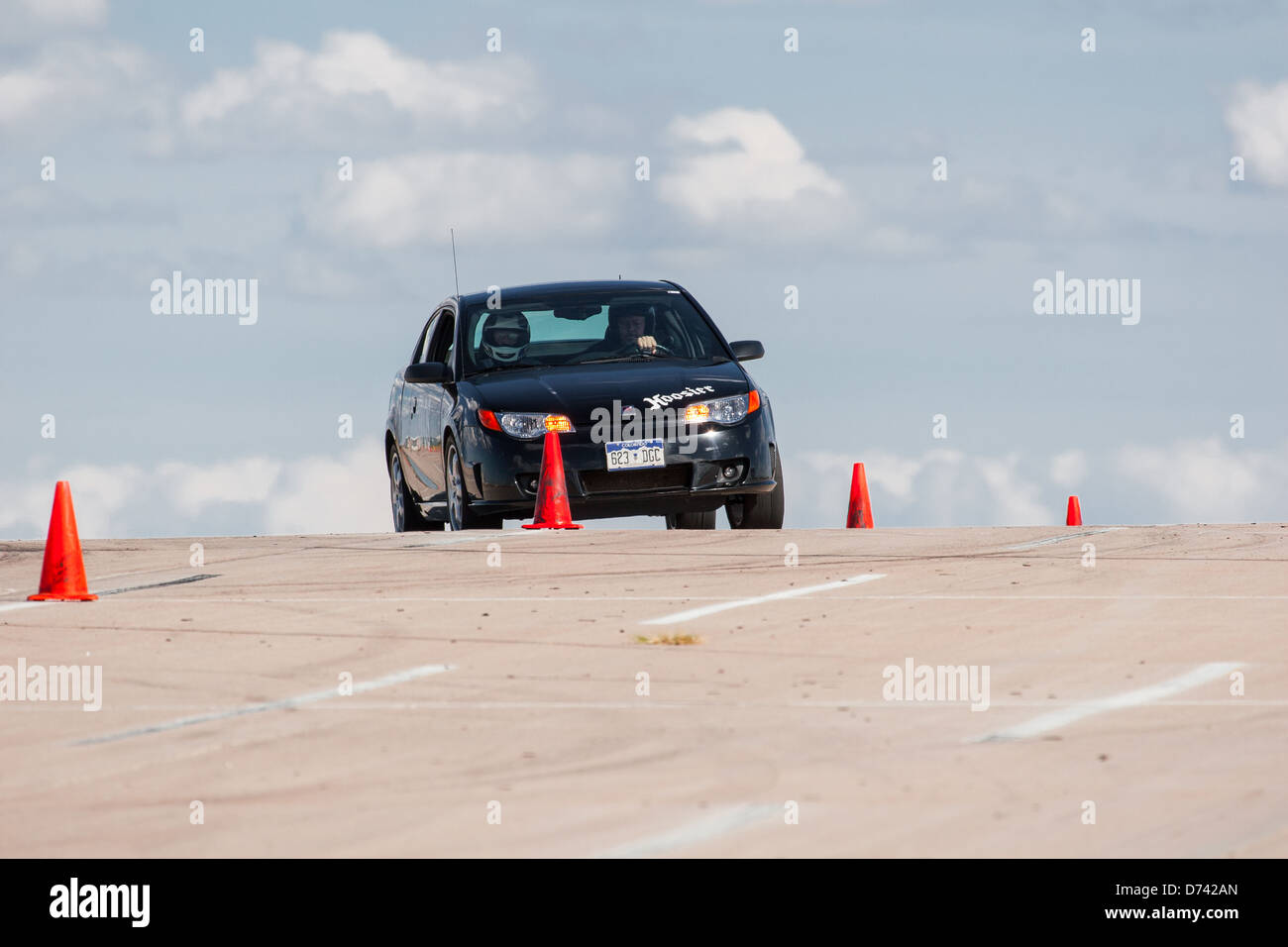 A 2006 Black Saturn Ion Redline automobile in an autocross race at a ...