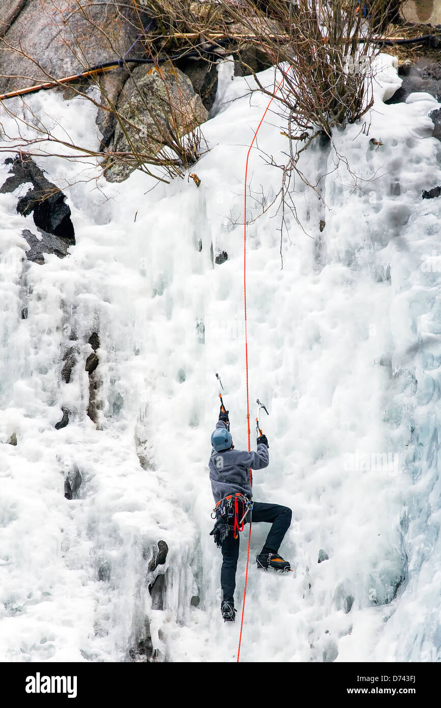 A Caucasian male ice climber struggles to ascend a waterfall Stock ...